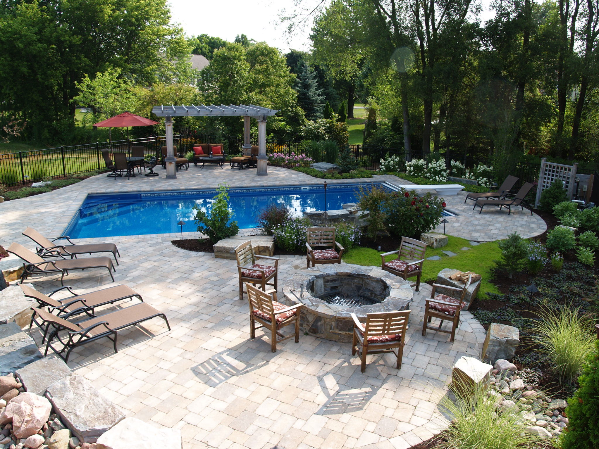 Separate conversation areas add versatility to this backyard design ...