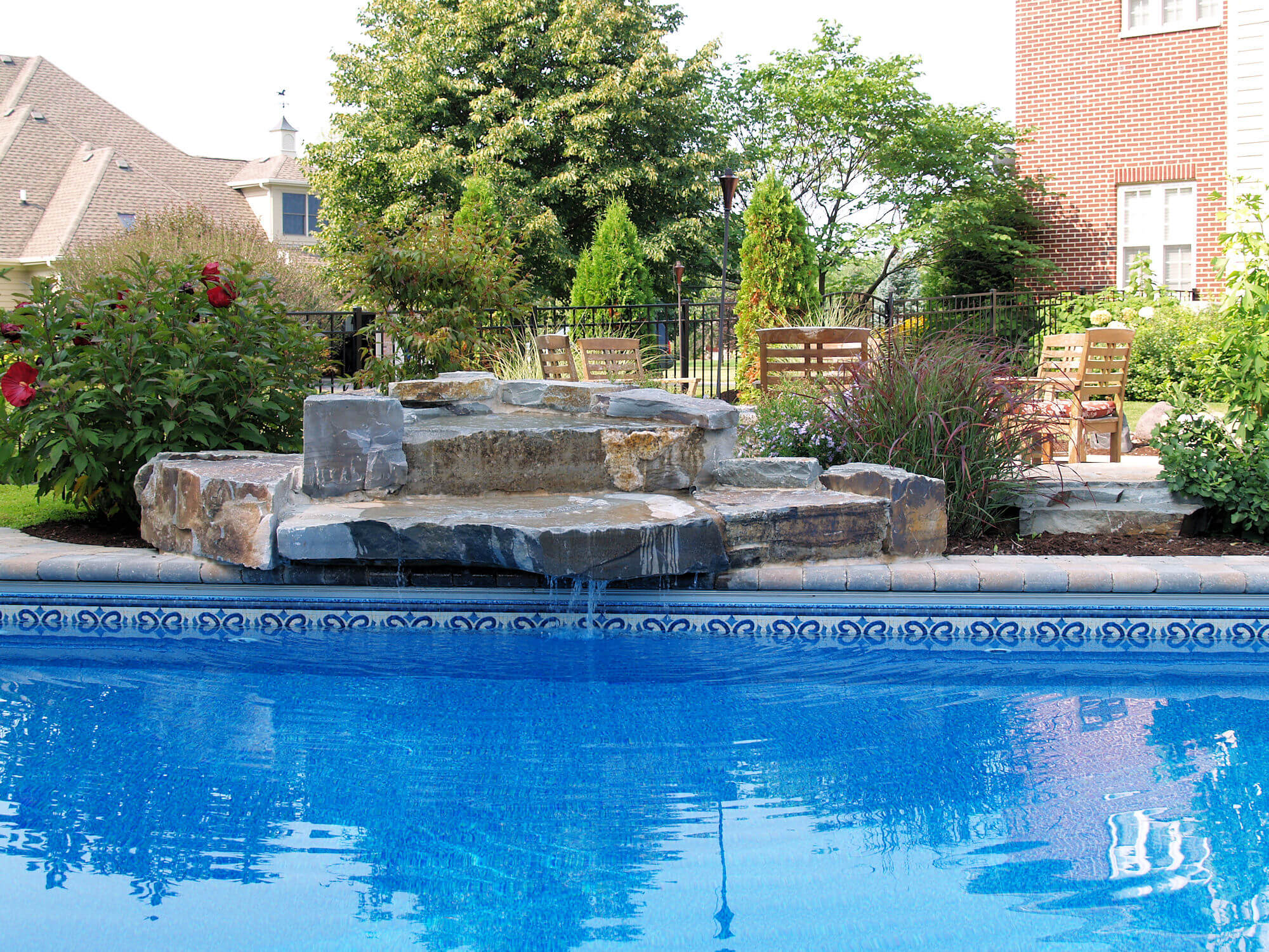 Landscaping and a rock fountain provide a beautiful backdrop to this ...