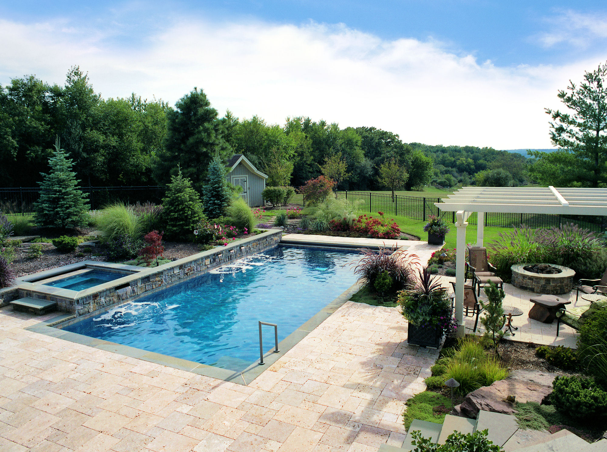 A custom spa and waterfalls add beautiful style to this pool design ...